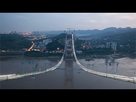 Workers walk on largest span dual-purpose suspension bridge in China ...
