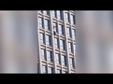 Fireman rescues man hanging upside down out of 13th-floor window in NE ...
