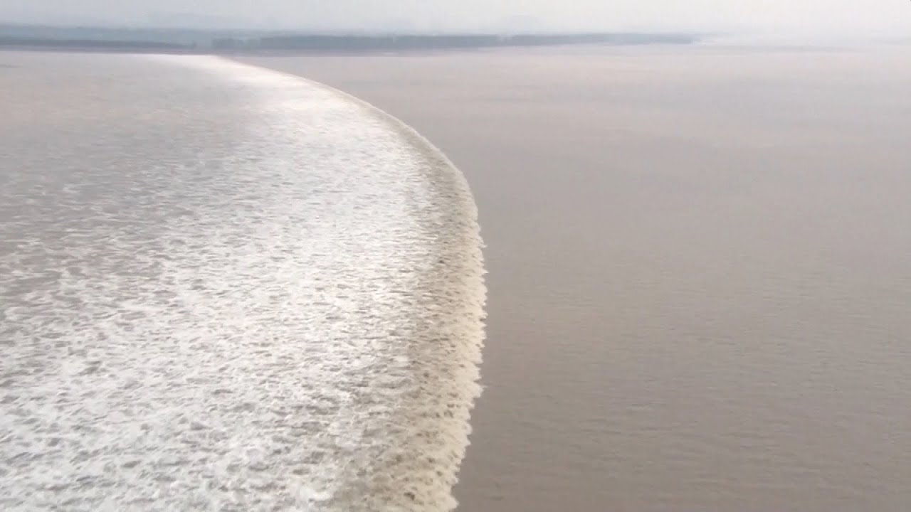 Onrushing tidal bore hitting onto Laoyancang dam, sending roaring ...