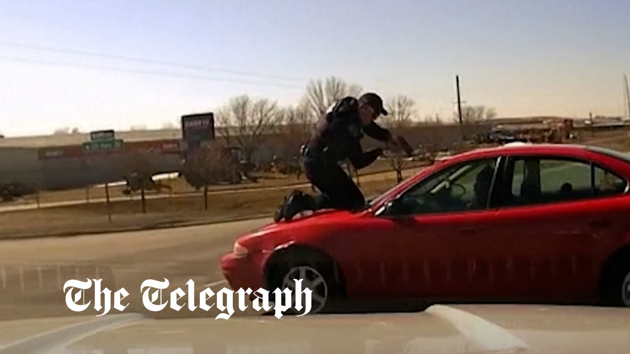 Police officer breaks back after clinging to car roof of suspect ...