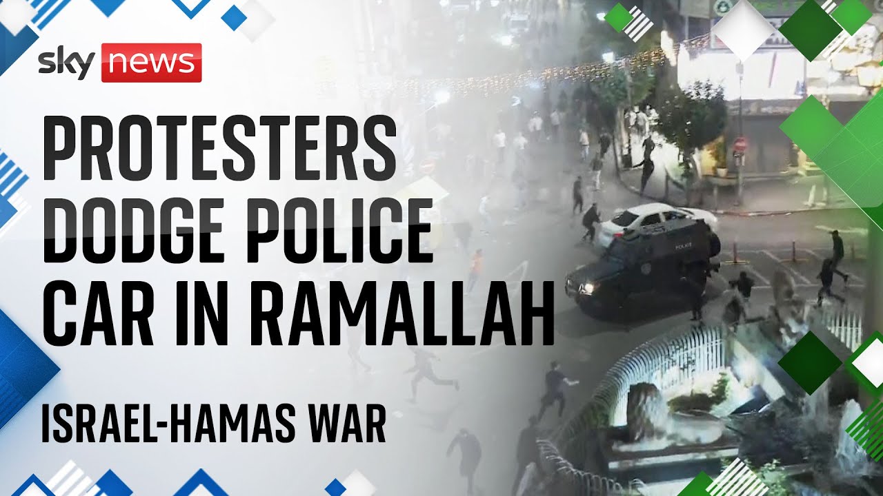 Protesters dodge a police car driving around a roundabout in Ramallah ...