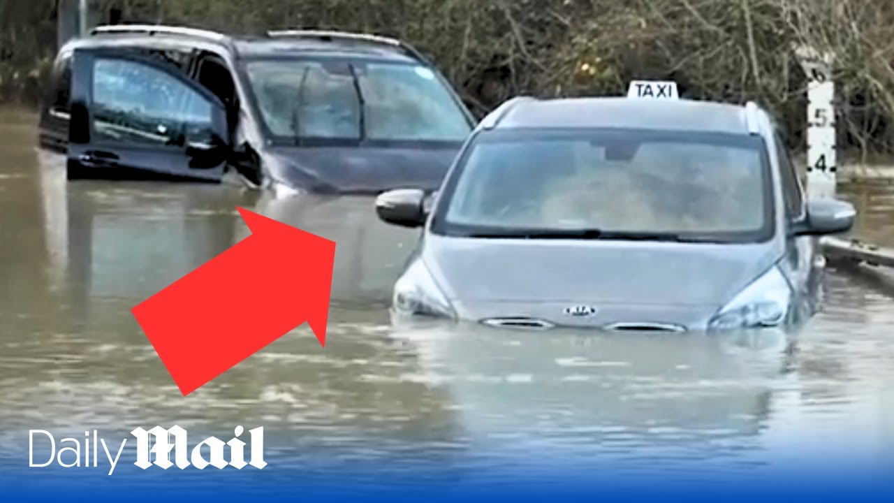 Driver and passengers rescued after taxi submerged in floodwater during ...